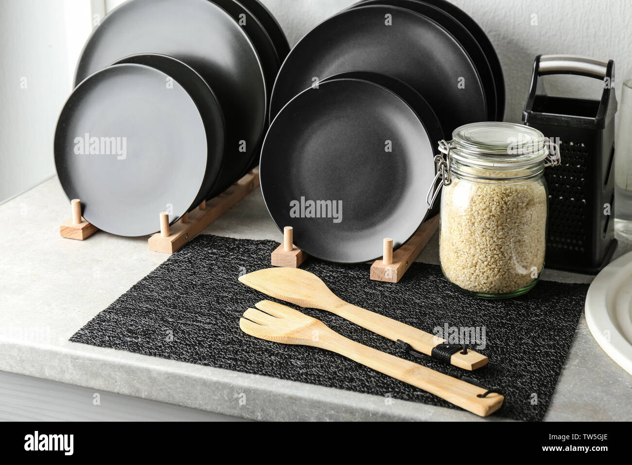 Kitchen table with set of black plates Stock Photo - Alamy
