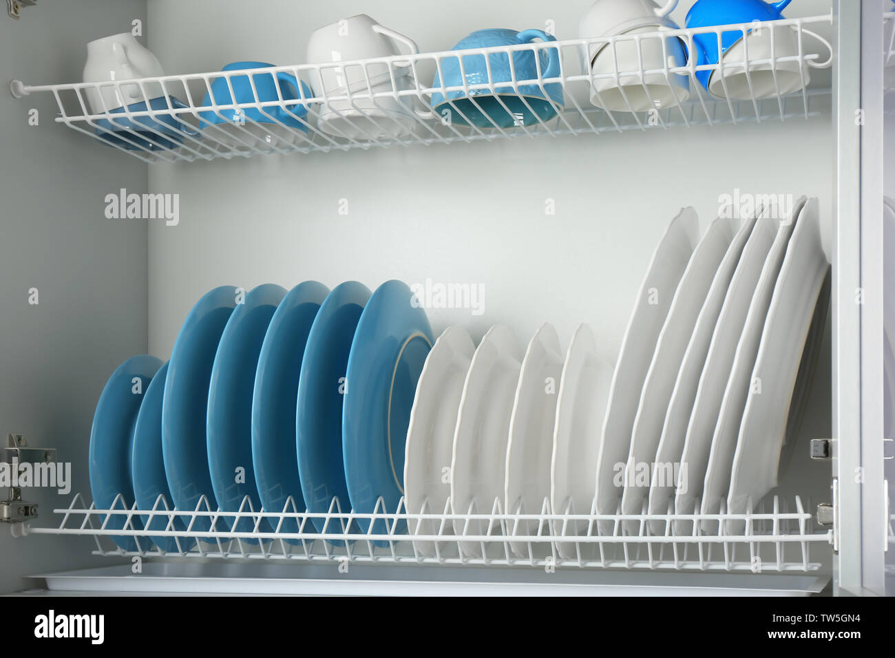 Set of white and blue tableware on drying rack in kitchen Stock Photo ...