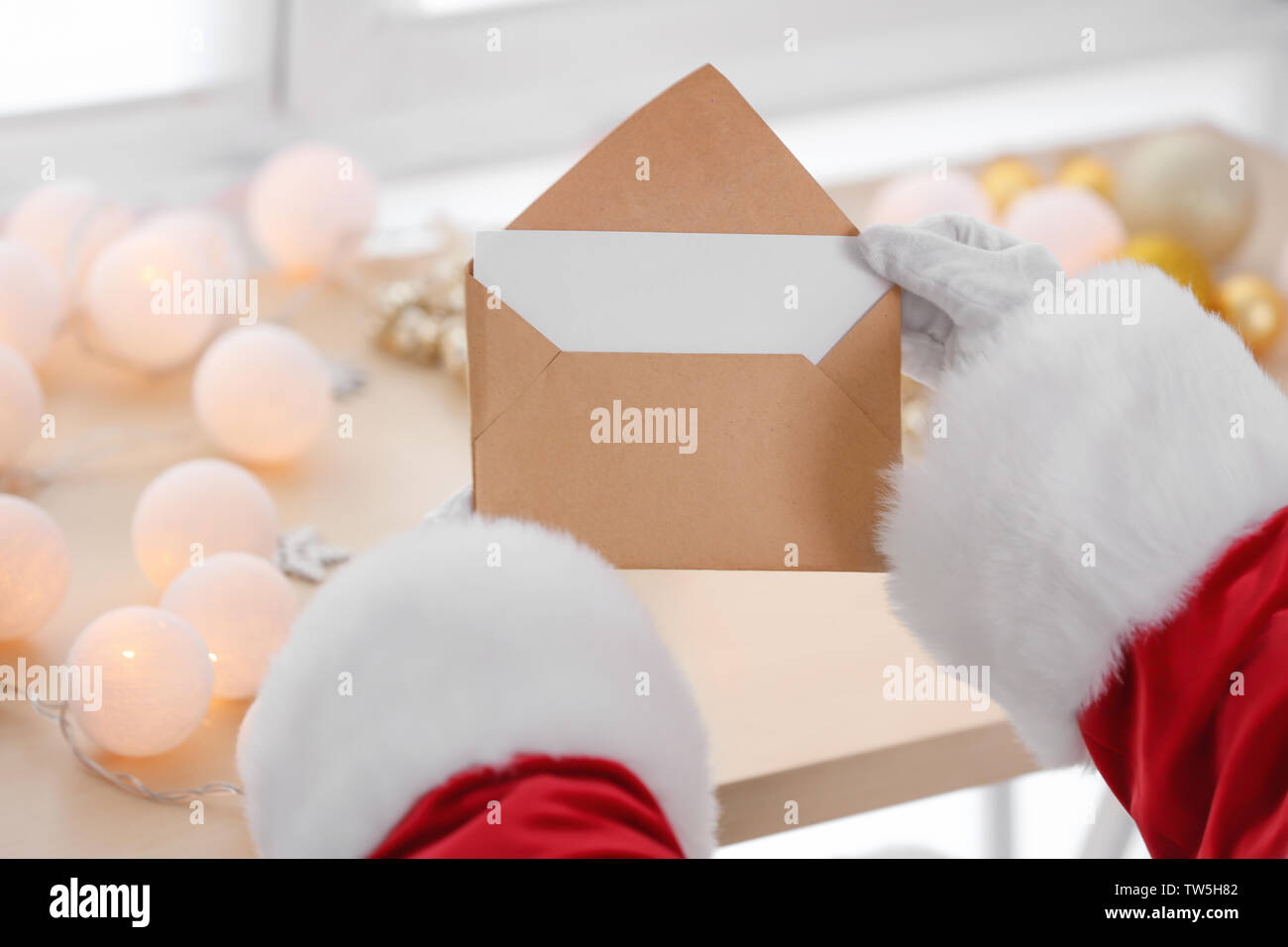 Santa Claus holding letter at table Stock Photo - Alamy