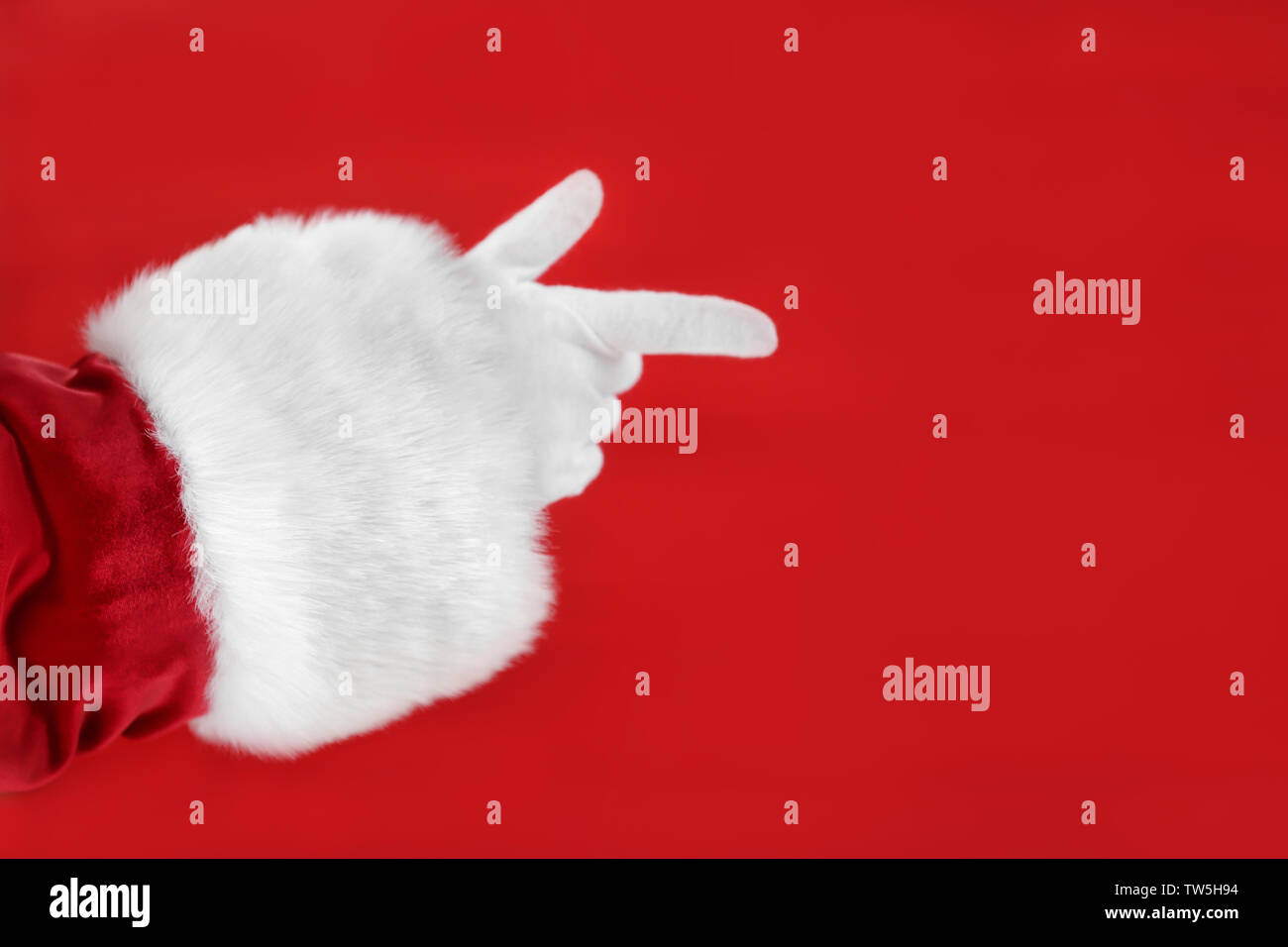 Santa Claus hand against red background Stock Photo - Alamy