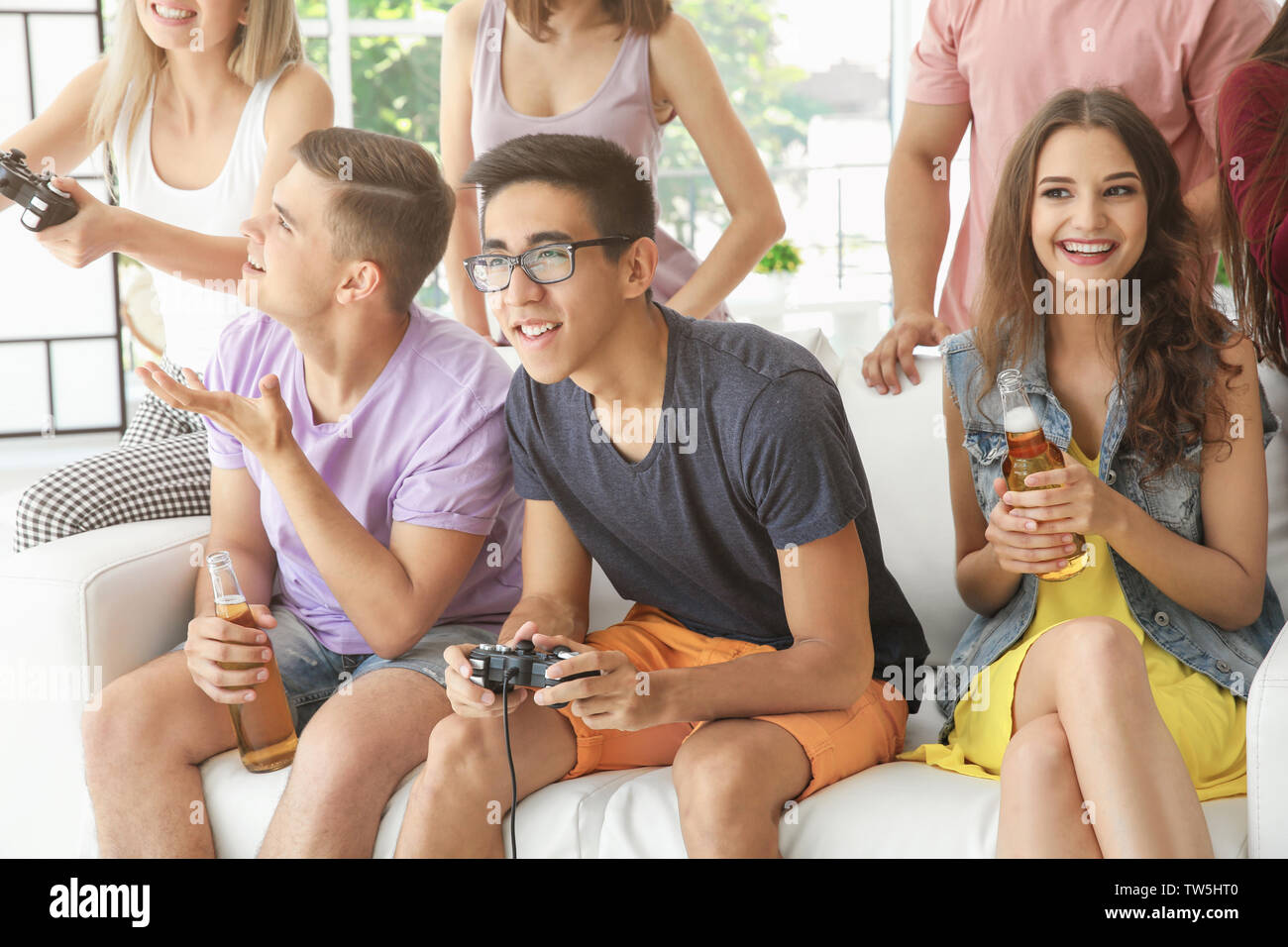 Friends playing video games on TV at home Stock Photo - Alamy