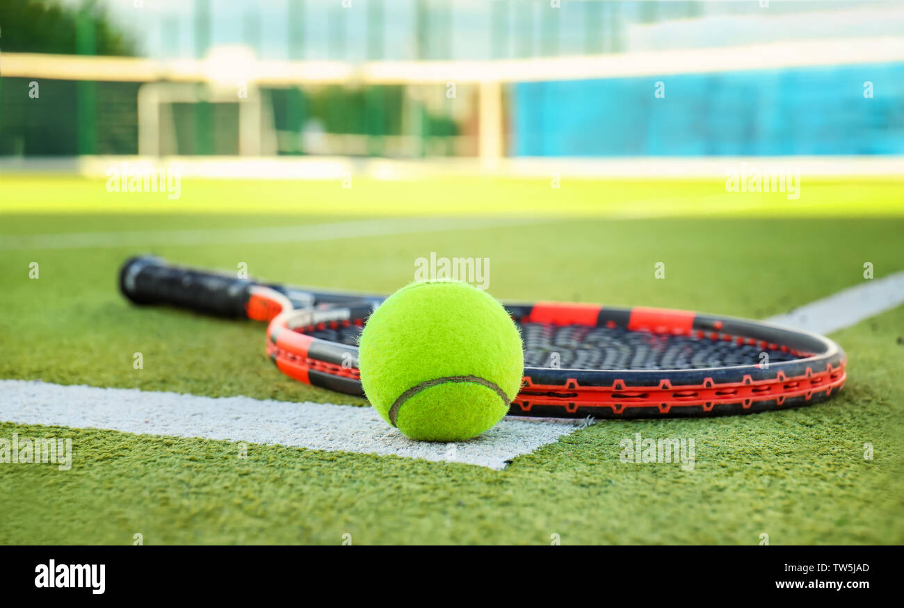 Tennis ball and racket on court Stock Photo - Alamy