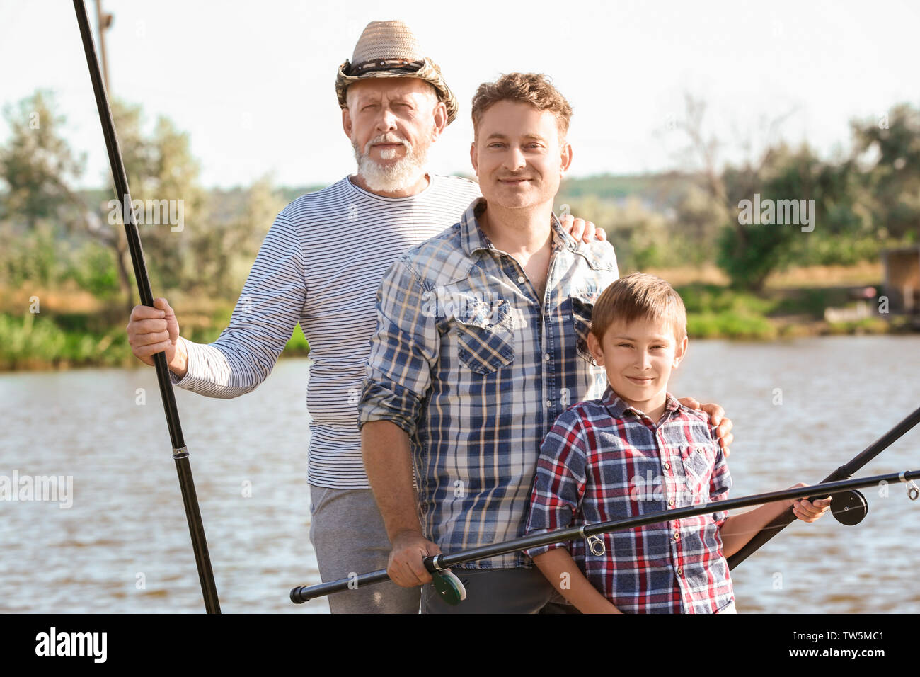 Family fishing on pond together Stock Photo - Alamy