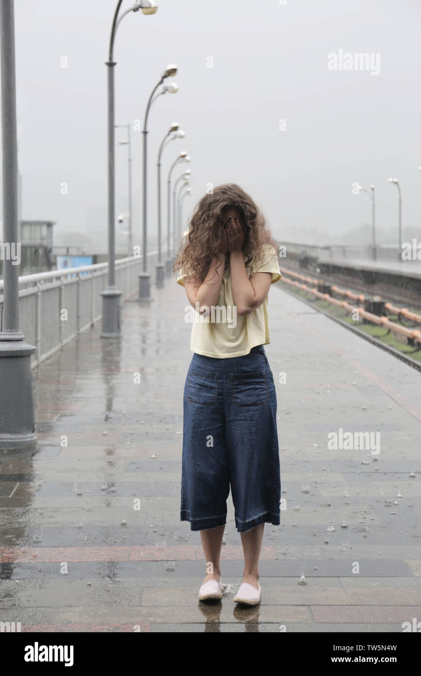 Depressed young woman on rainy day outdoors Stock Photo - Alamy