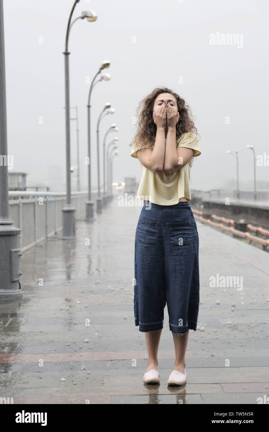 Depressed young woman on rainy day outdoors Stock Photo - Alamy