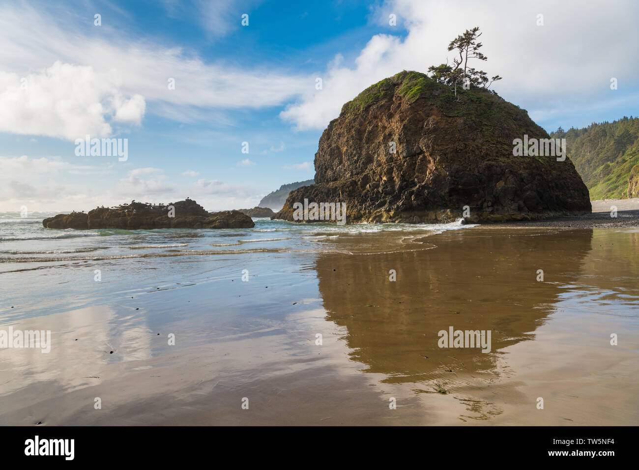 A sea stack rock formation and a beautiful blue sky with swirling white ...