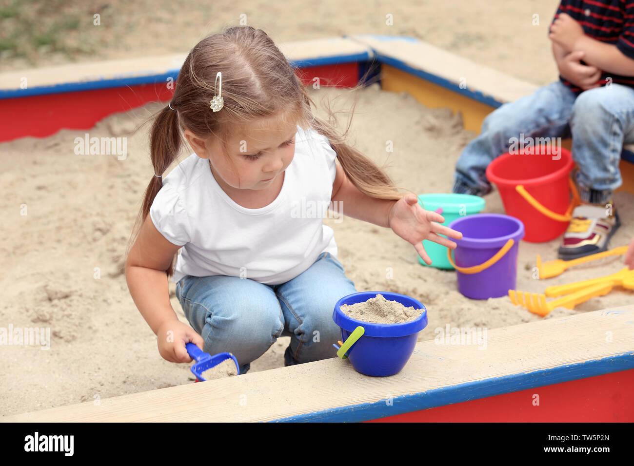 Cute little children playing in sandbox, outdoors Stock Photo - Alamy
