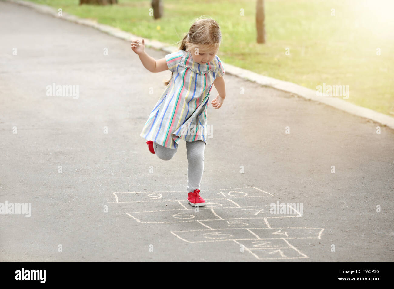 Cute little girl playing hopscotch, outdoors Stock Photo - Alamy