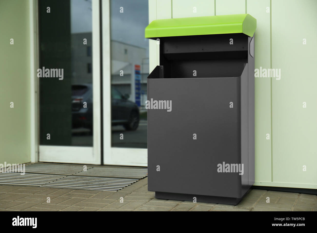 Modern garbage bin near entrance to building, outdoors Stock Photo - Alamy