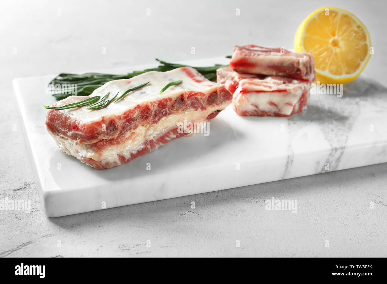 Marble board with fresh raw pork ribs on kitchen table Stock Photo - Alamy