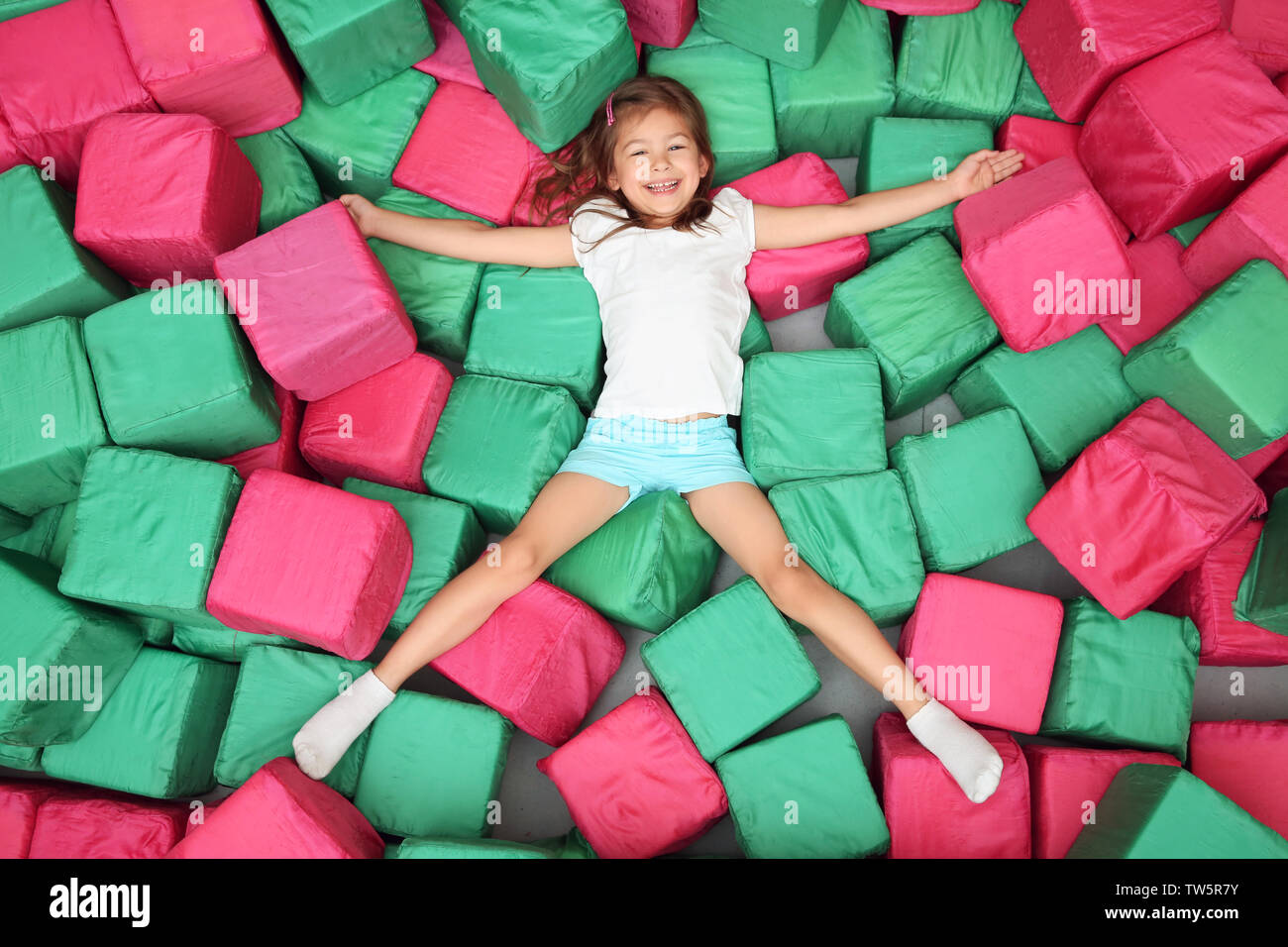 Cute girl playing among soft cubes Stock Photo - Alamy