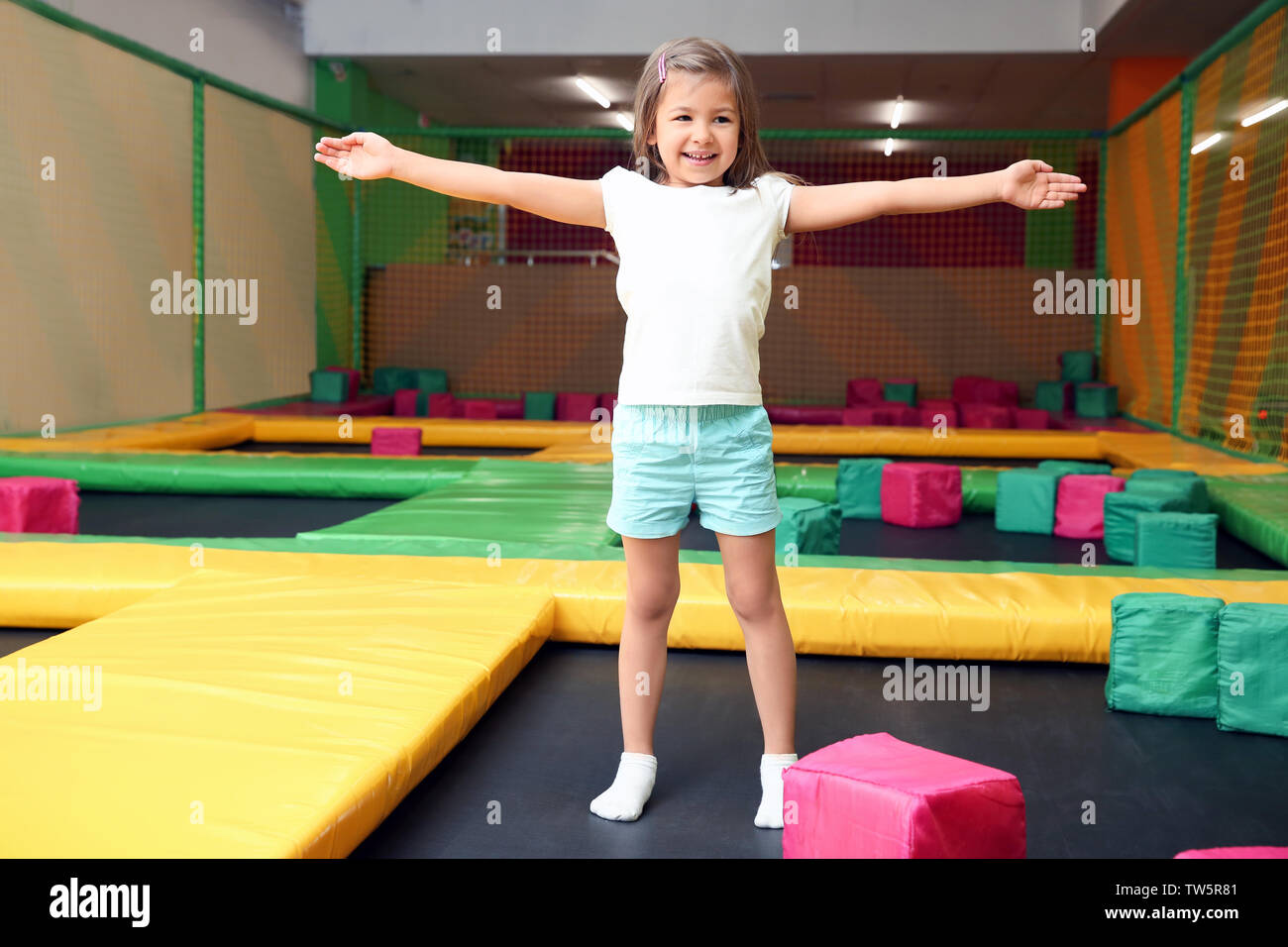 Cute girl jumping on trampoline in entertainment center Stock Photo - Alamy