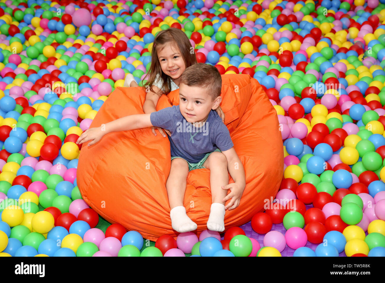 Cute children playing among plastic balls Stock Photo - Alamy
