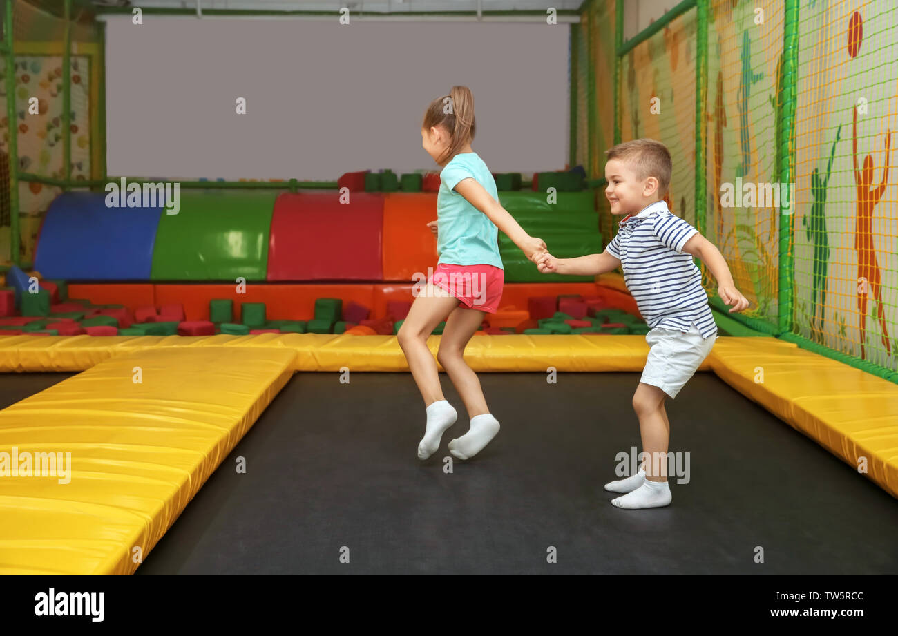 Cute children jumping on trampoline in entertainment center Stock Photo ...