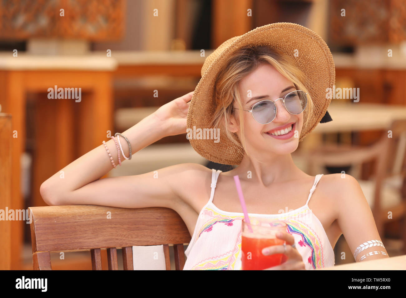 Beautiful young woman drinking lemonade in cafe Stock Photo - Alamy