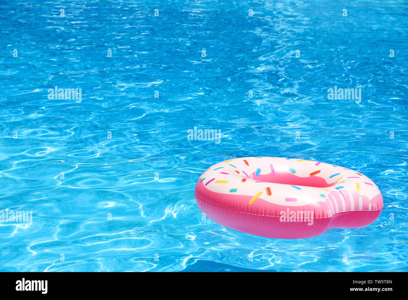 Inflatable colorful donut in blue swimming pool Stock Photo - Alamy