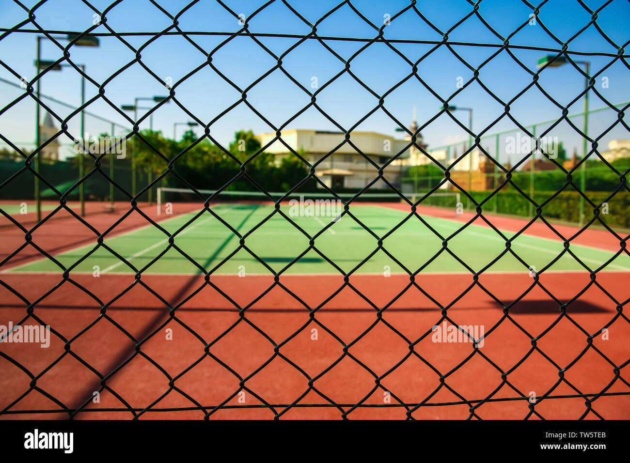 Beautiful tennis court at sunny day, view through mesh fence Stock ...
