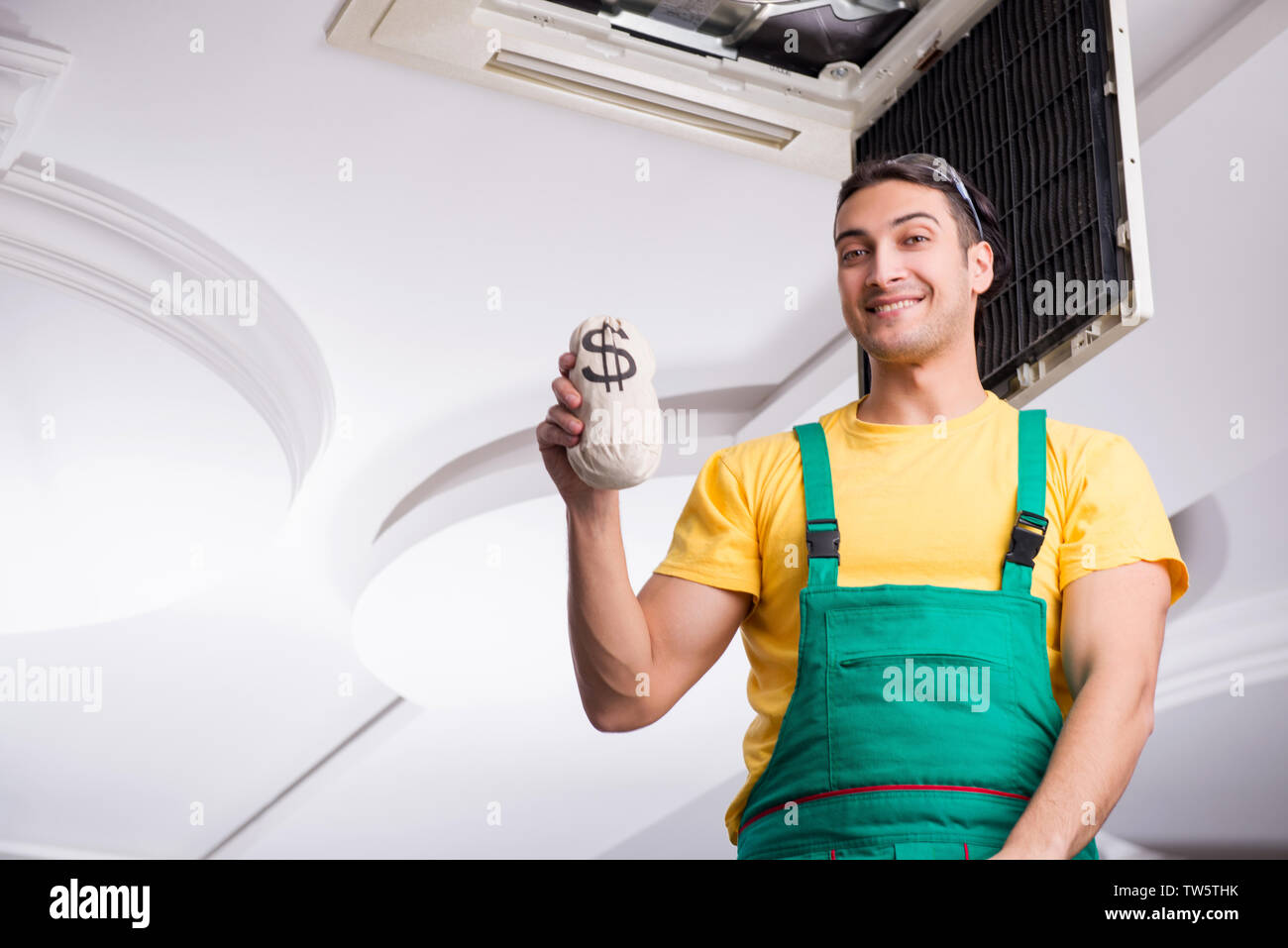 Young repairman repairing ceiling air conditioning unit Stock Photo - Alamy