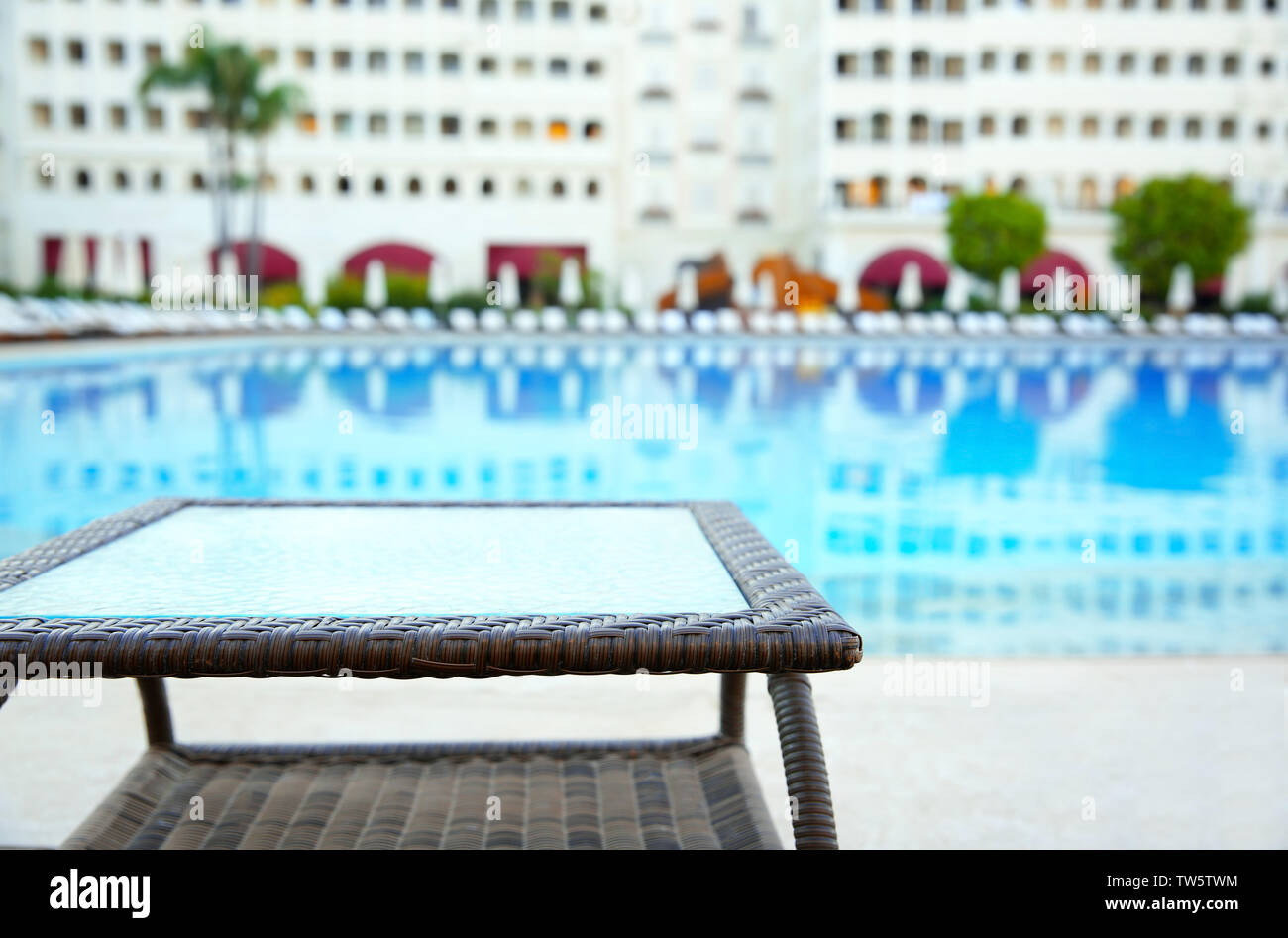 Rattan table near swimming pool in luxury hotel Stock Photo - Alamy
