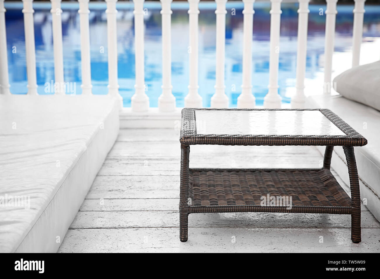 Rattan table near swimming pool in luxury hotel Stock Photo - Alamy