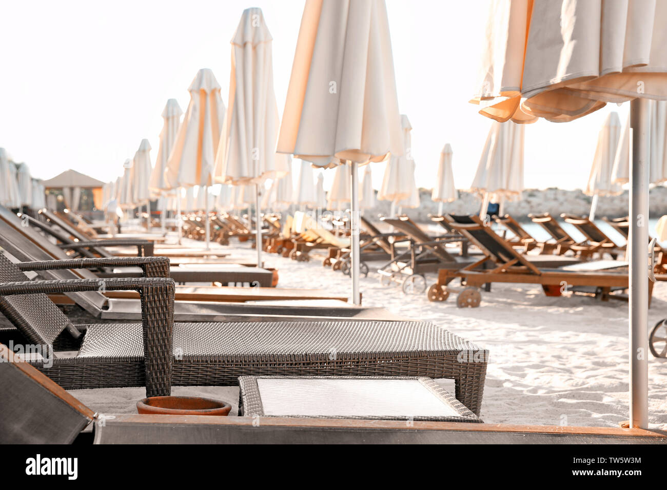 Empty sunbeds with patio umbrellas on beach Stock Photo - Alamy