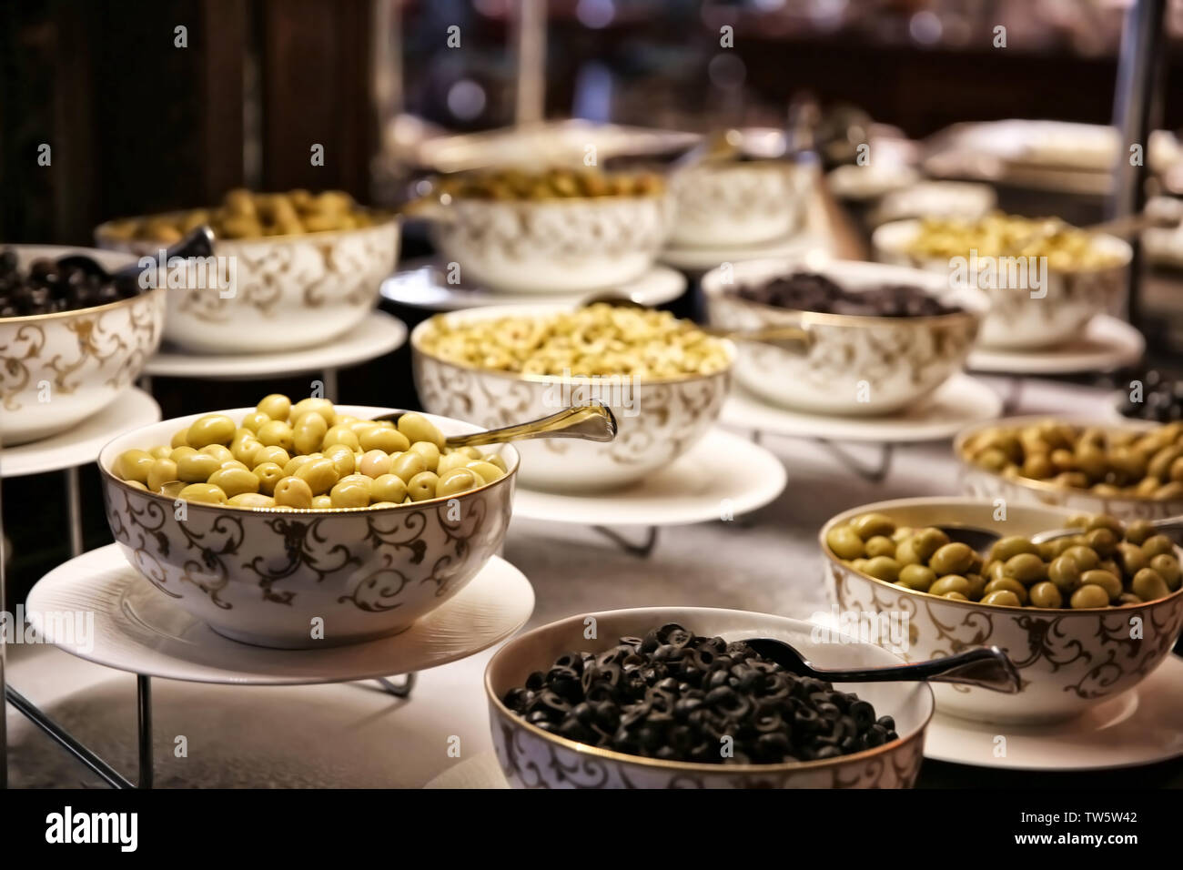 Different kinds of olives in bowls on table at buffet Stock Photo - Alamy