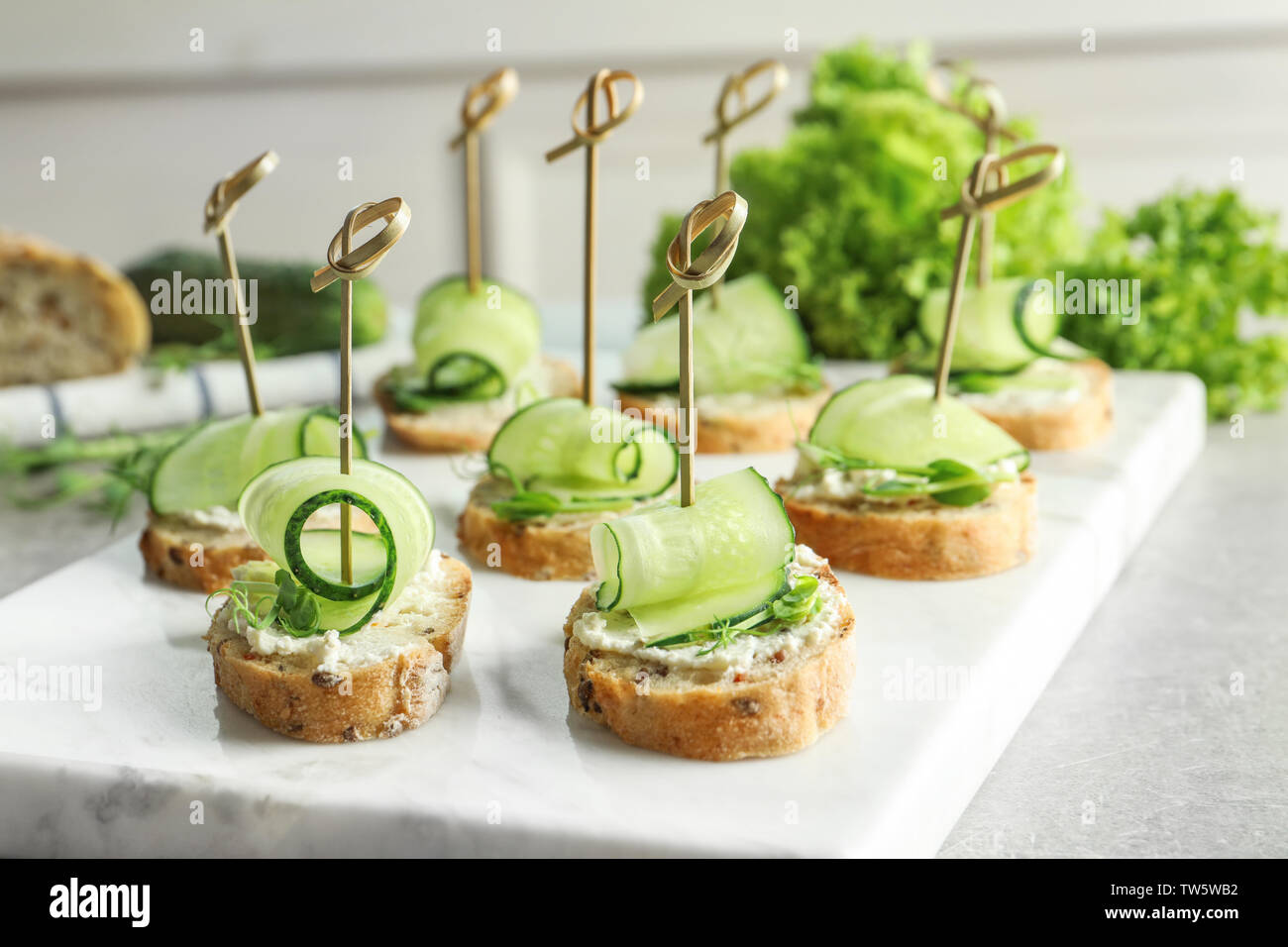 Set of delicious canapes with fresh cucumber on board Stock Photo - Alamy