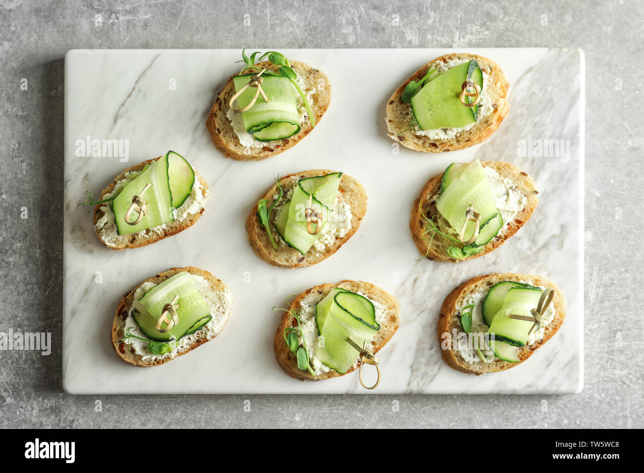 Set of delicious canapes with fresh cucumber on board Stock Photo - Alamy