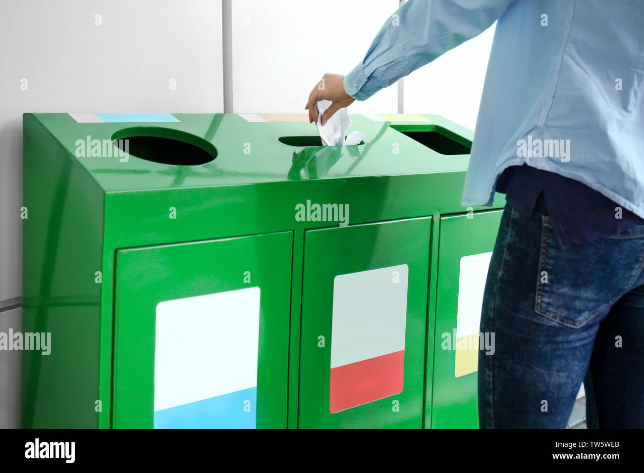 Woman throwing paper into litter bin outdoors Stock Photo - Alamy