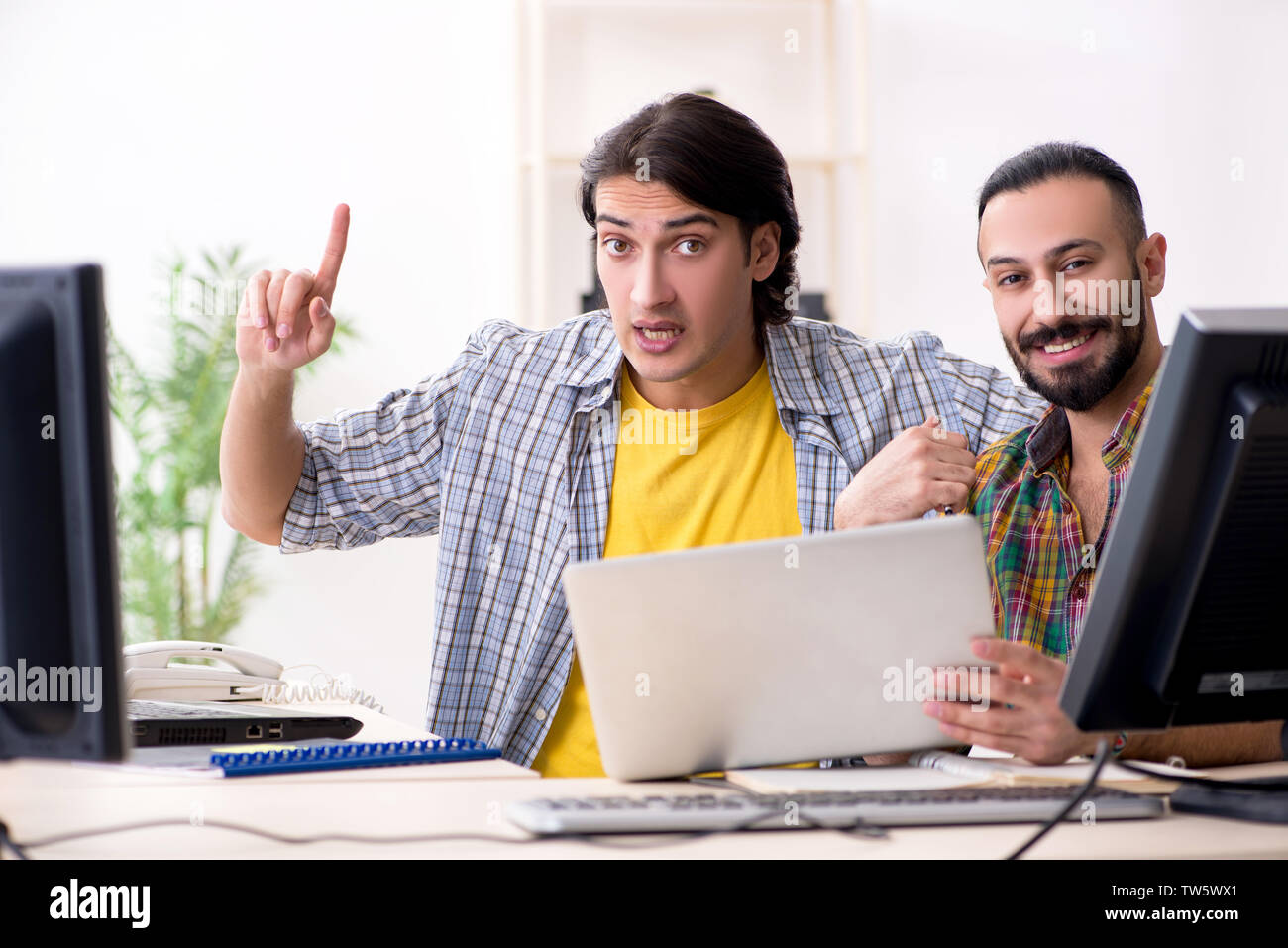 Two it specialists working in the office Stock Photo - Alamy