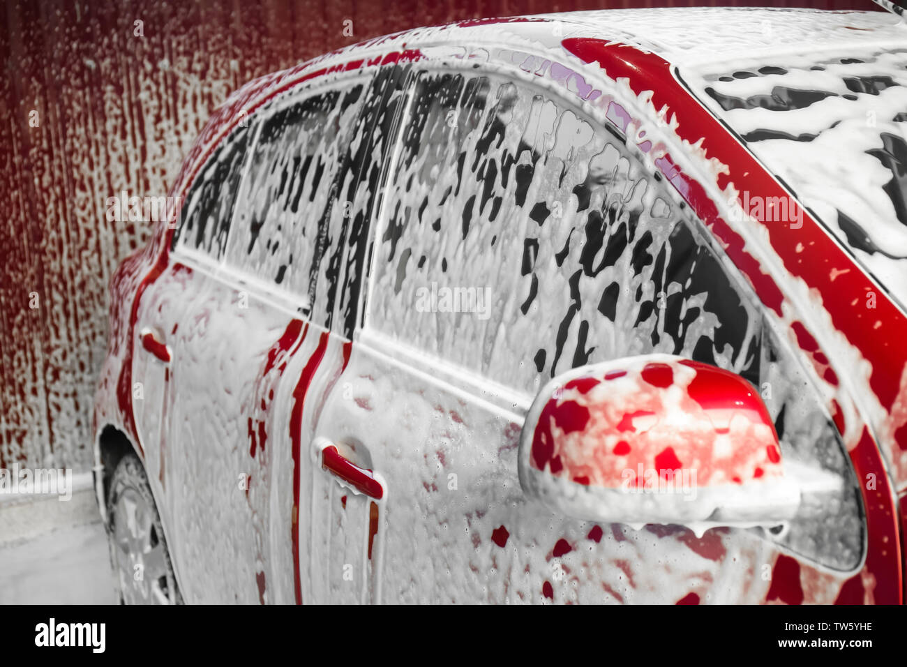Red automobile in foam at car wash Stock Photo - Alamy