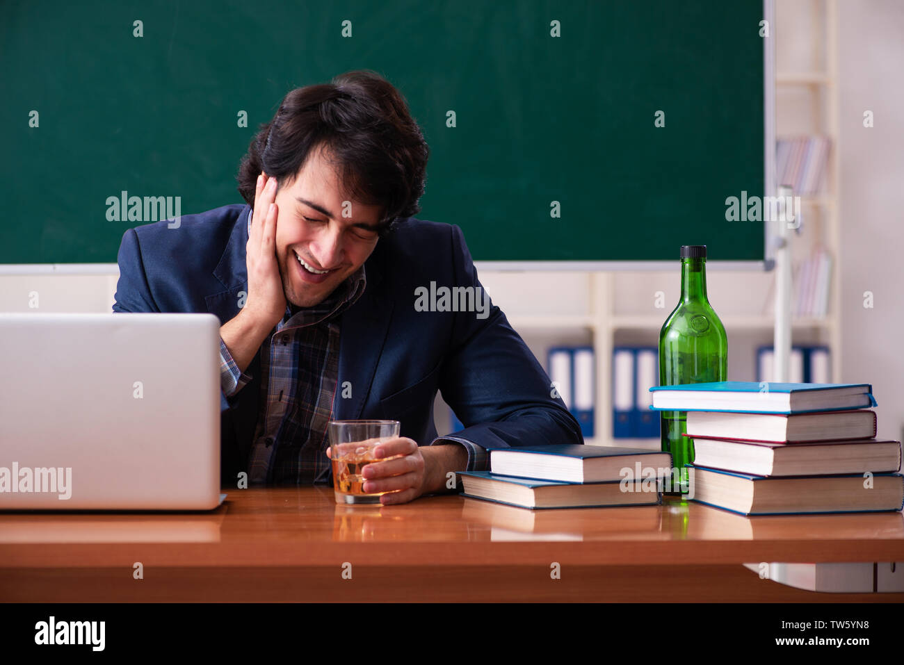 Male teacher drinking in the classroom Stock Photo - Alamy