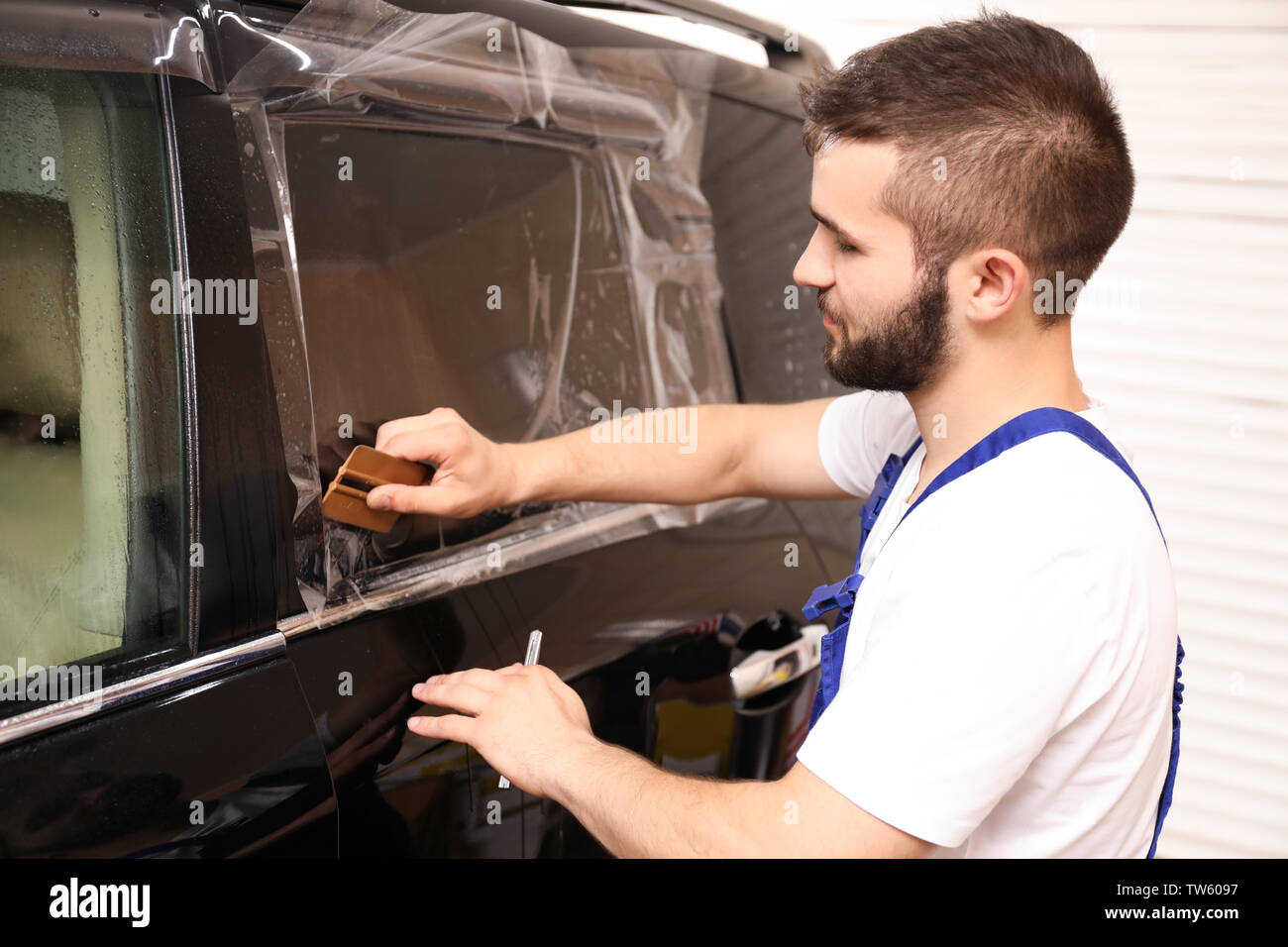 Worker tinting car window in shop Stock Photo - Alamy