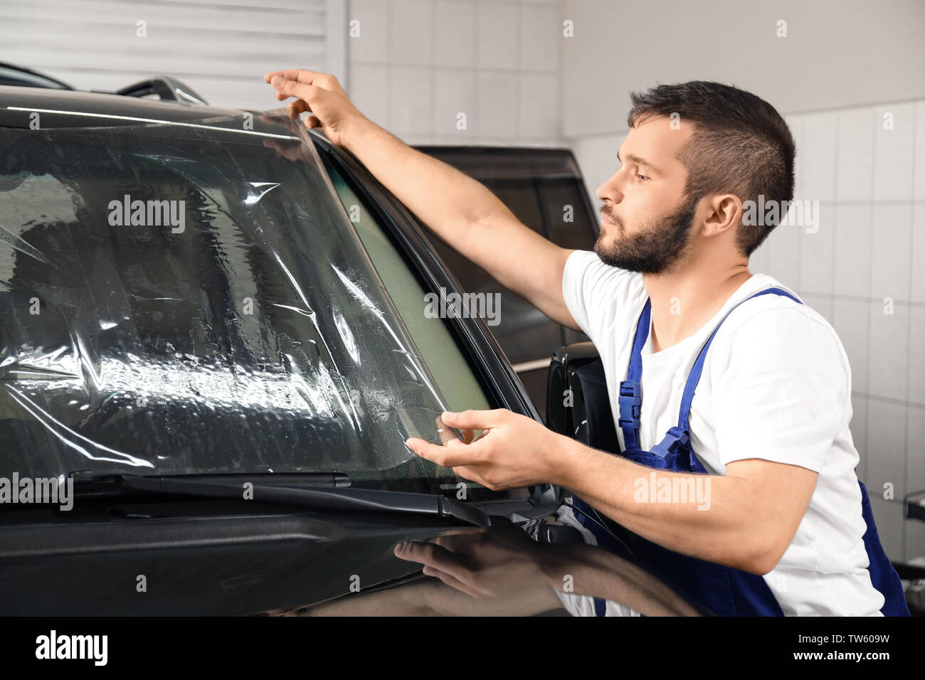 Worker tinting car window in shop Stock Photo - Alamy