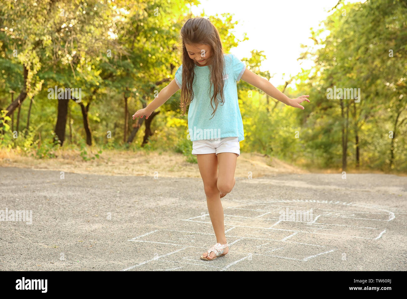 Cute little girl playing hopscotch, outdoors Stock Photo - Alamy
