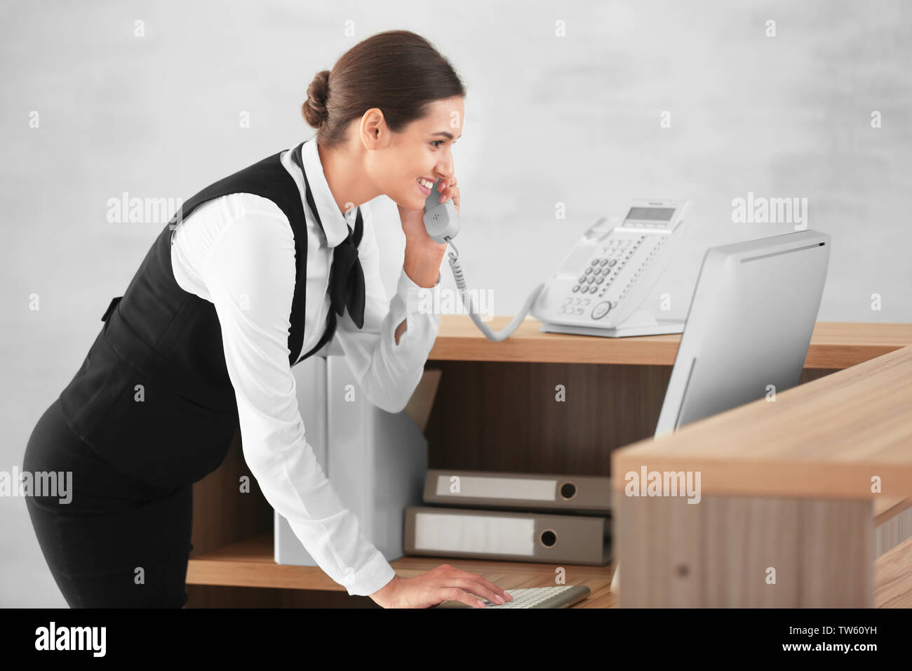 Female receptionist talking on phone in hotel Stock Photo - Alamy
