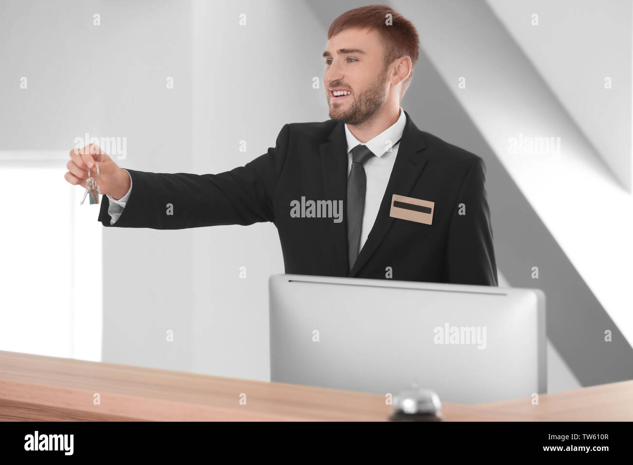 Male receptionist with room key in hotel Stock Photo - Alamy