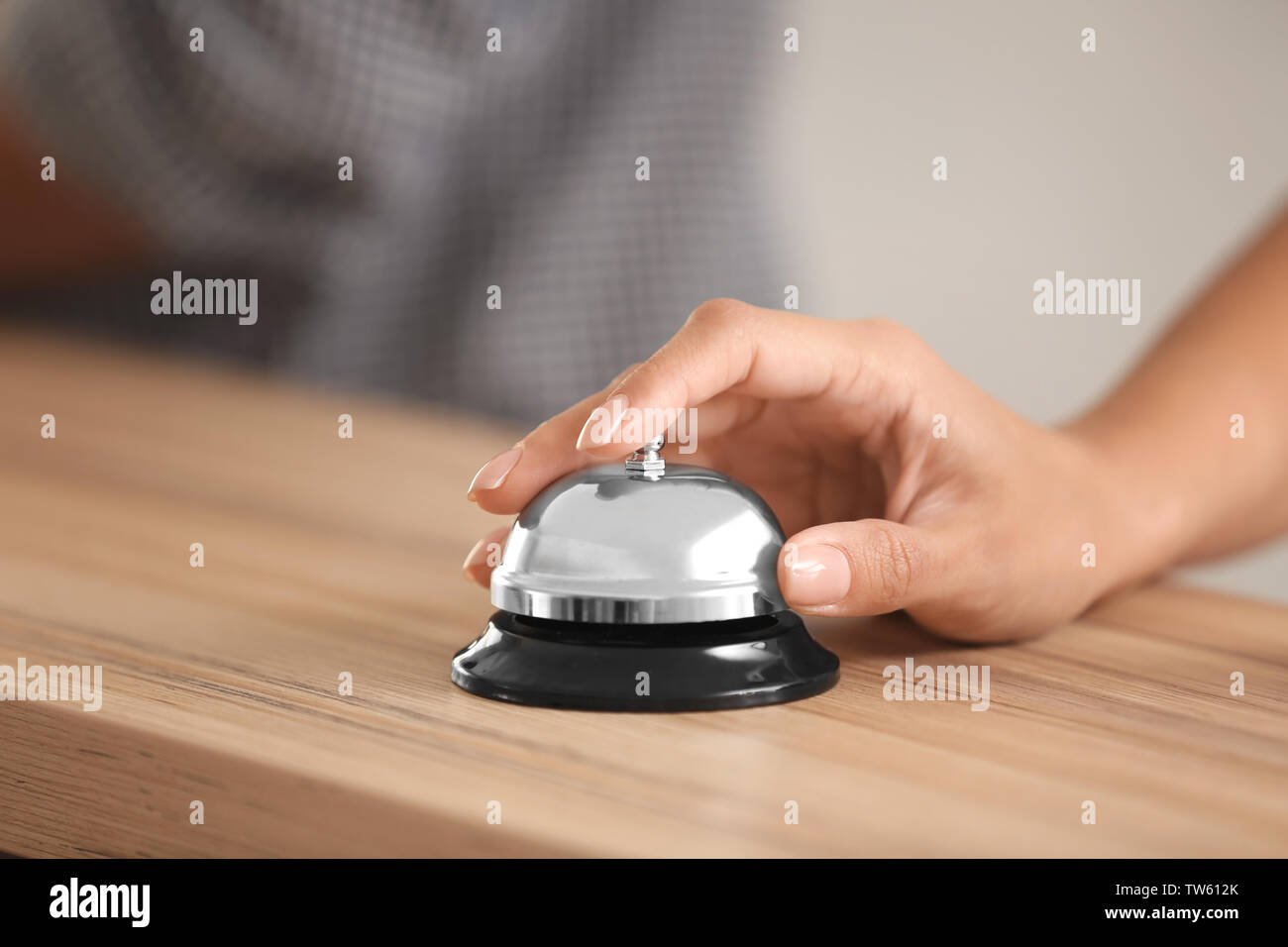 Woman ringing service bell at hotel reception Stock Photo - Alamy