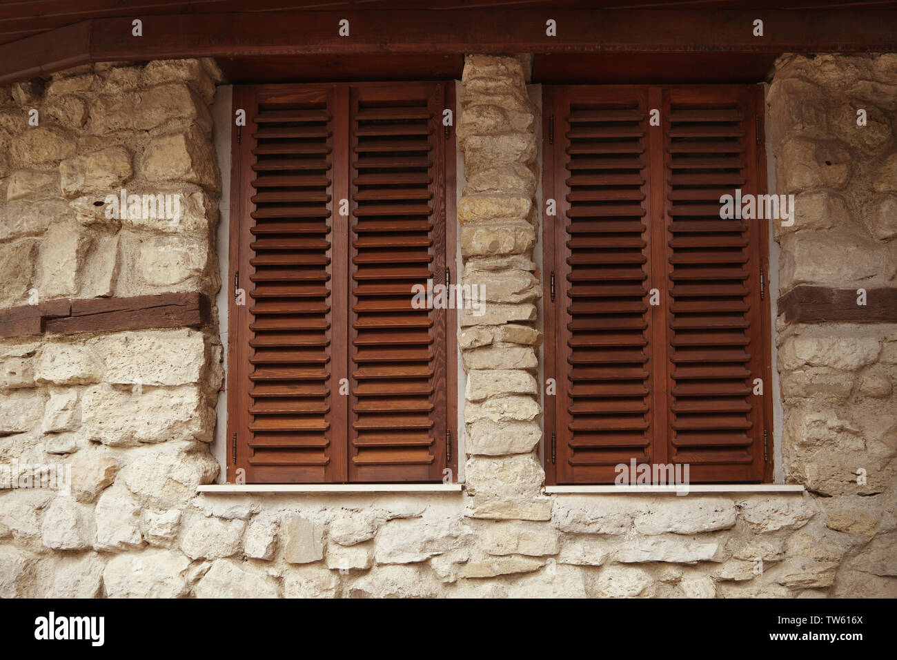 Stone wall with two shuttered windows Stock Photo - Alamy