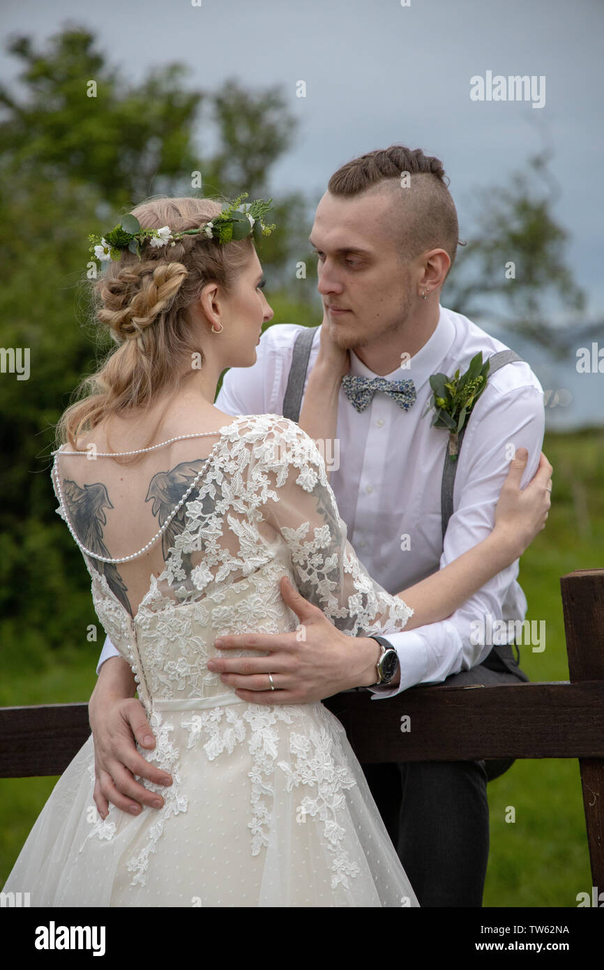 Wedding couple embrace across farm fence, Jennycliff, Plymouth, Devon ...