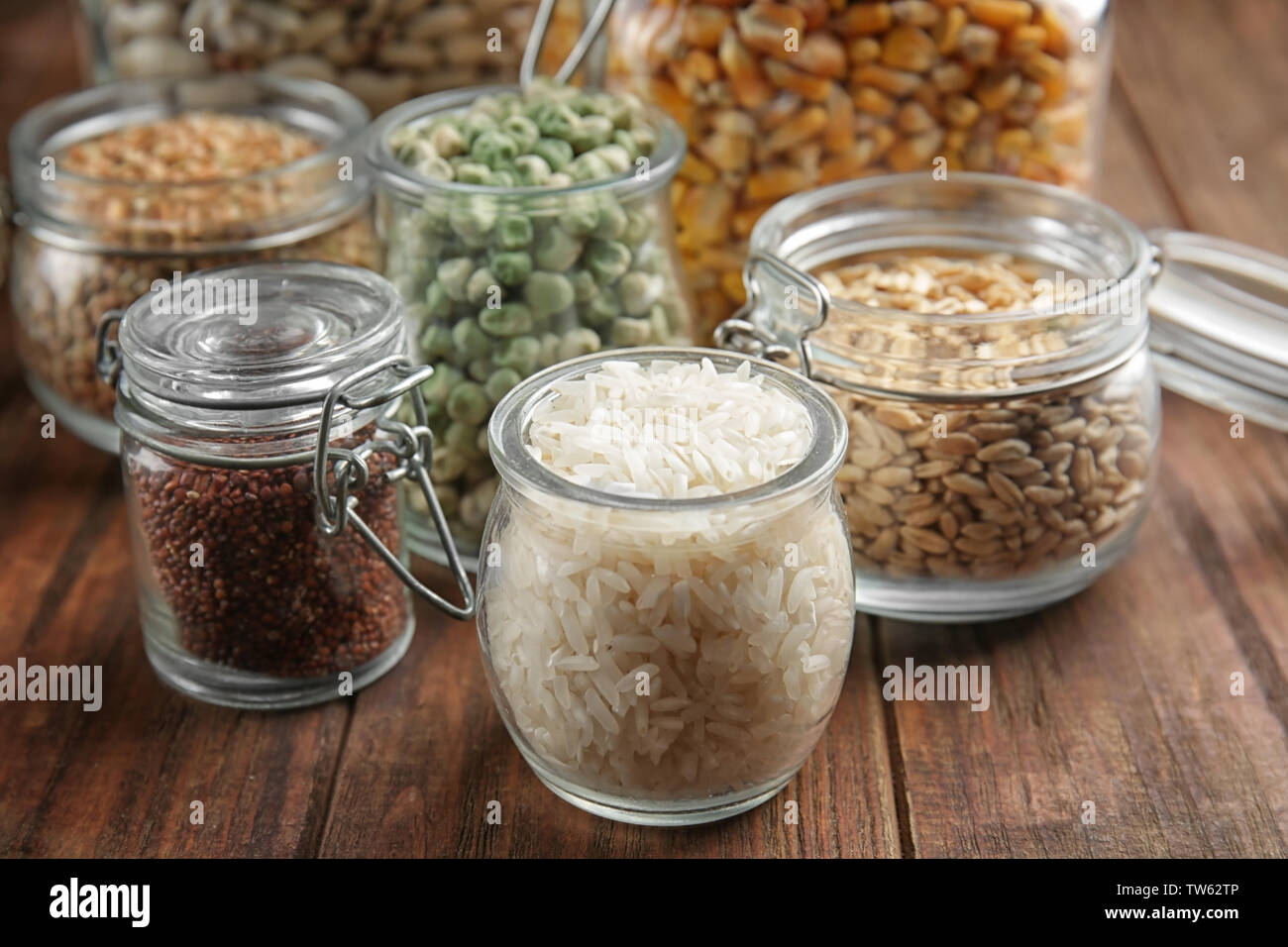 Glass jars with different grains on kitchen table Stock Photo - Alamy