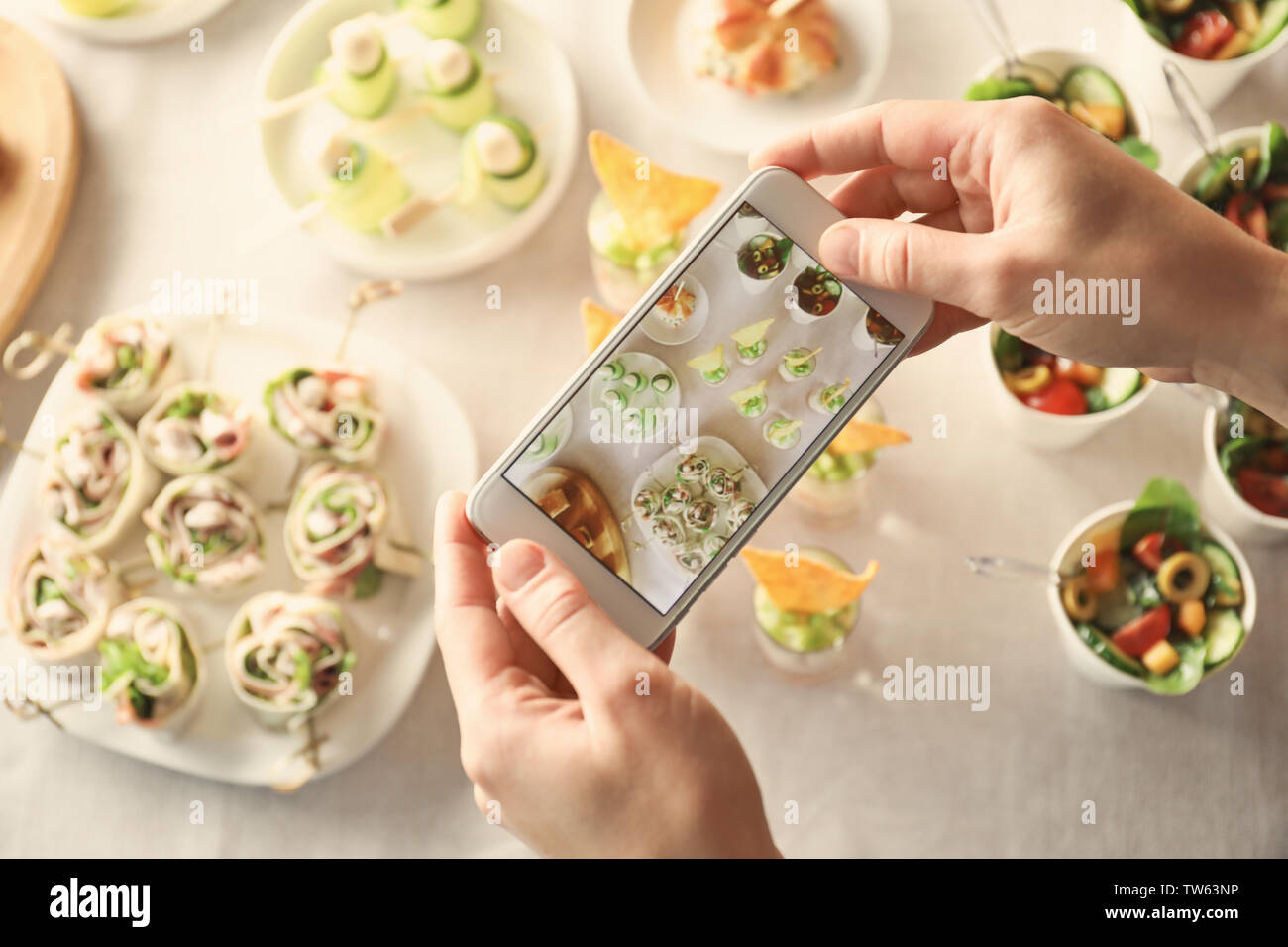 Blogger making photo of food with cell phone Stock Photo - Alamy