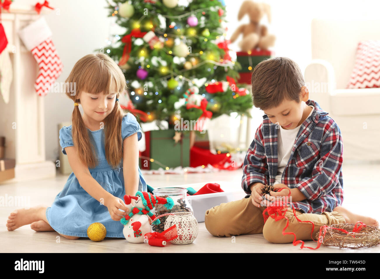 Cute children making Christmas handicrafts on floor Stock Photo - Alamy