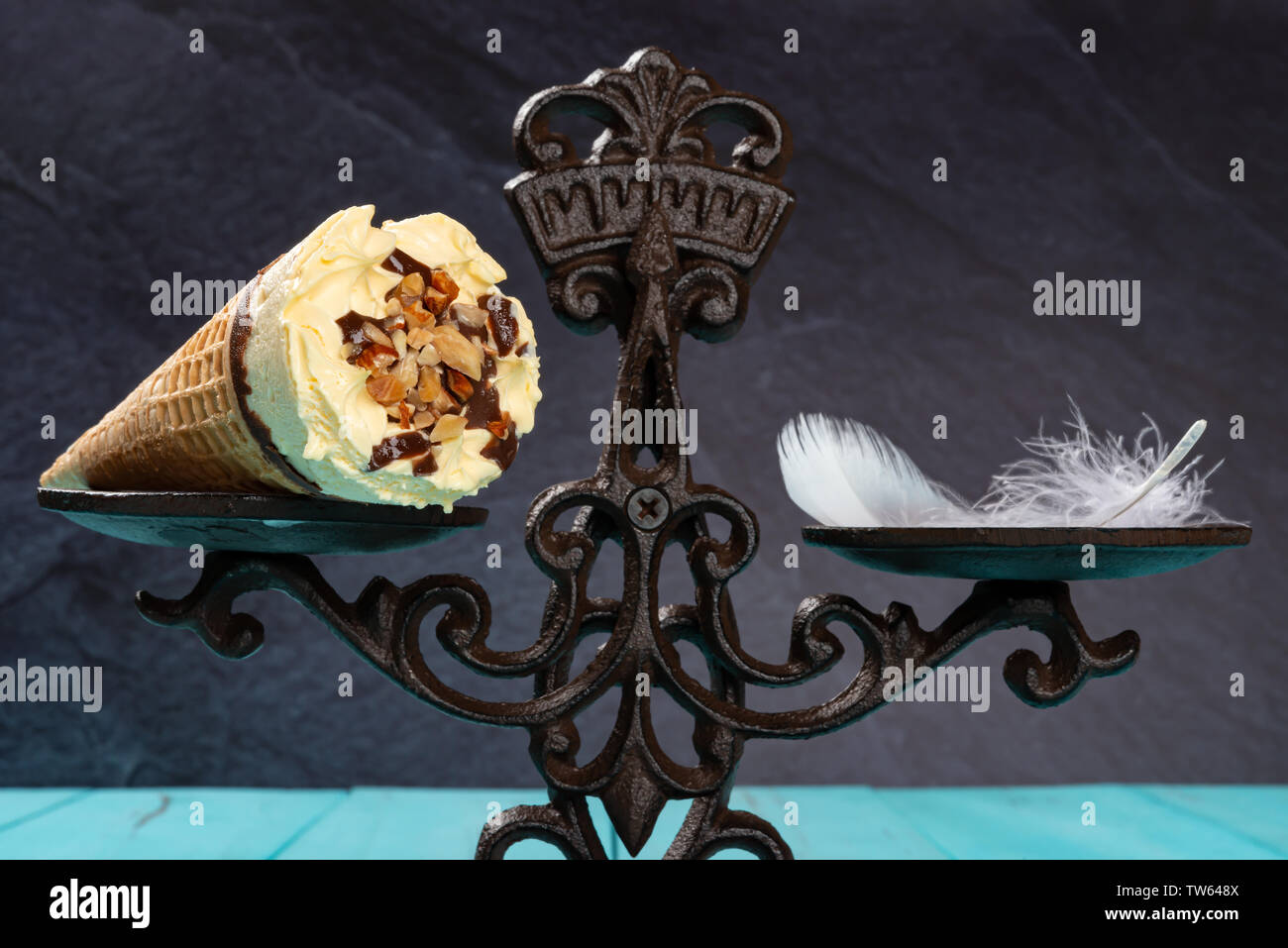 close up of ice cream cone and feather on a balanced scale concept of ...
