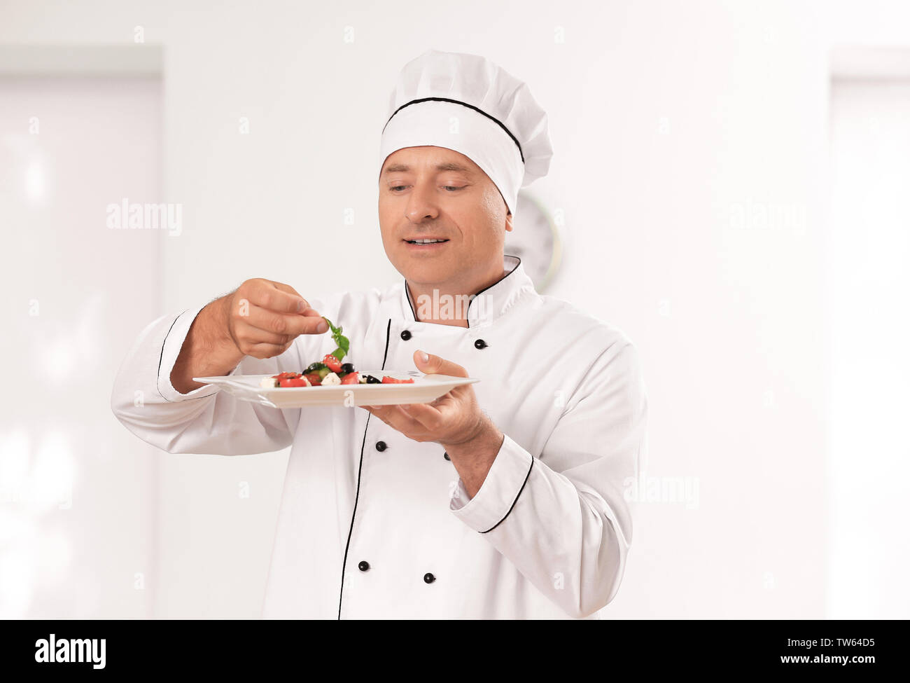 Male chef making salad in kitchen Stock Photo - Alamy