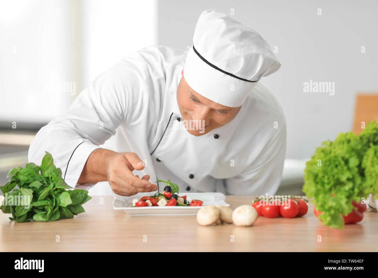 Male chef making salad in kitchen Stock Photo - Alamy