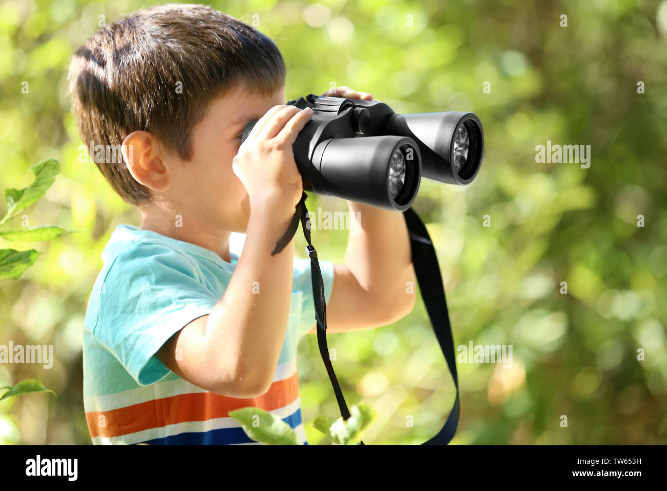 Cute boy looking through binoculars outdoors Stock Photo - Alamy