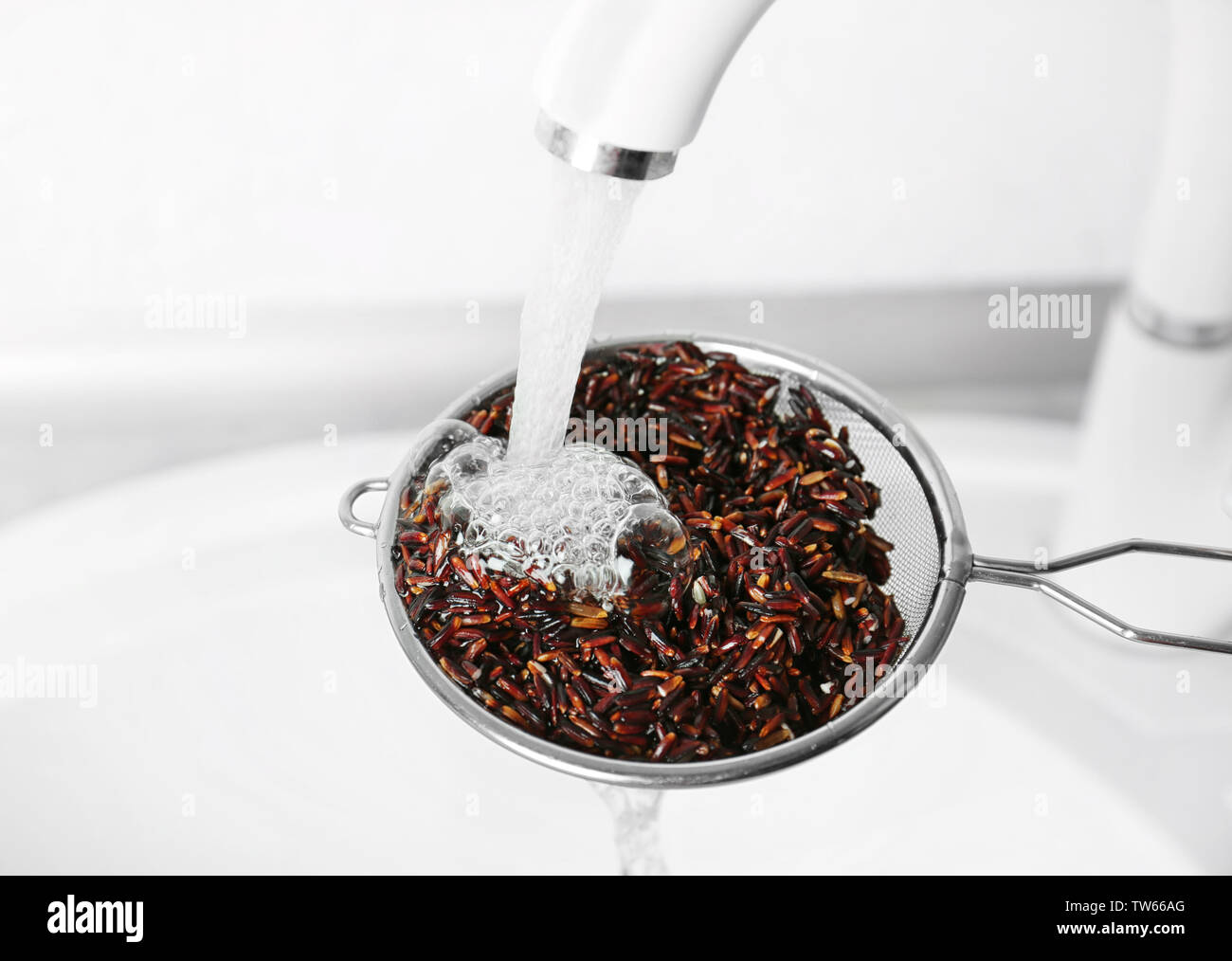 Washing raw rice with water in kitchen Stock Photo - Alamy