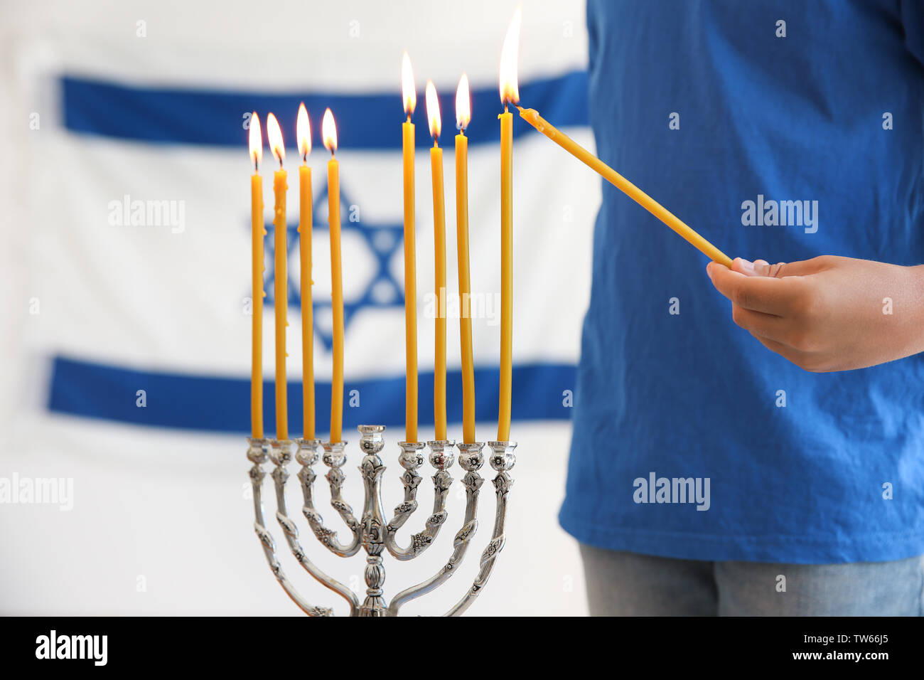 Jewish boy lightning menorah at home Stock Photo - Alamy