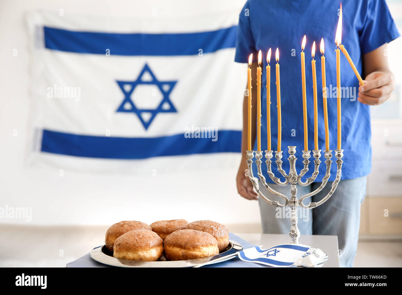 Jewish boy lightning menorah at home Stock Photo - Alamy